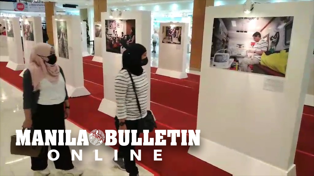 Mall goers take a glimpse of the photo exhibition featuring former Pres ...