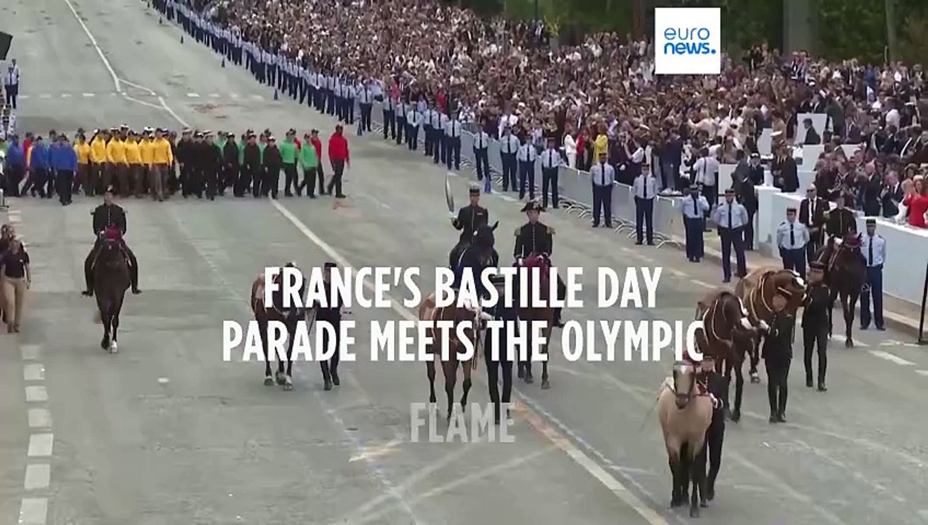 The Olympic torch lights up France's Bastille Day military parade